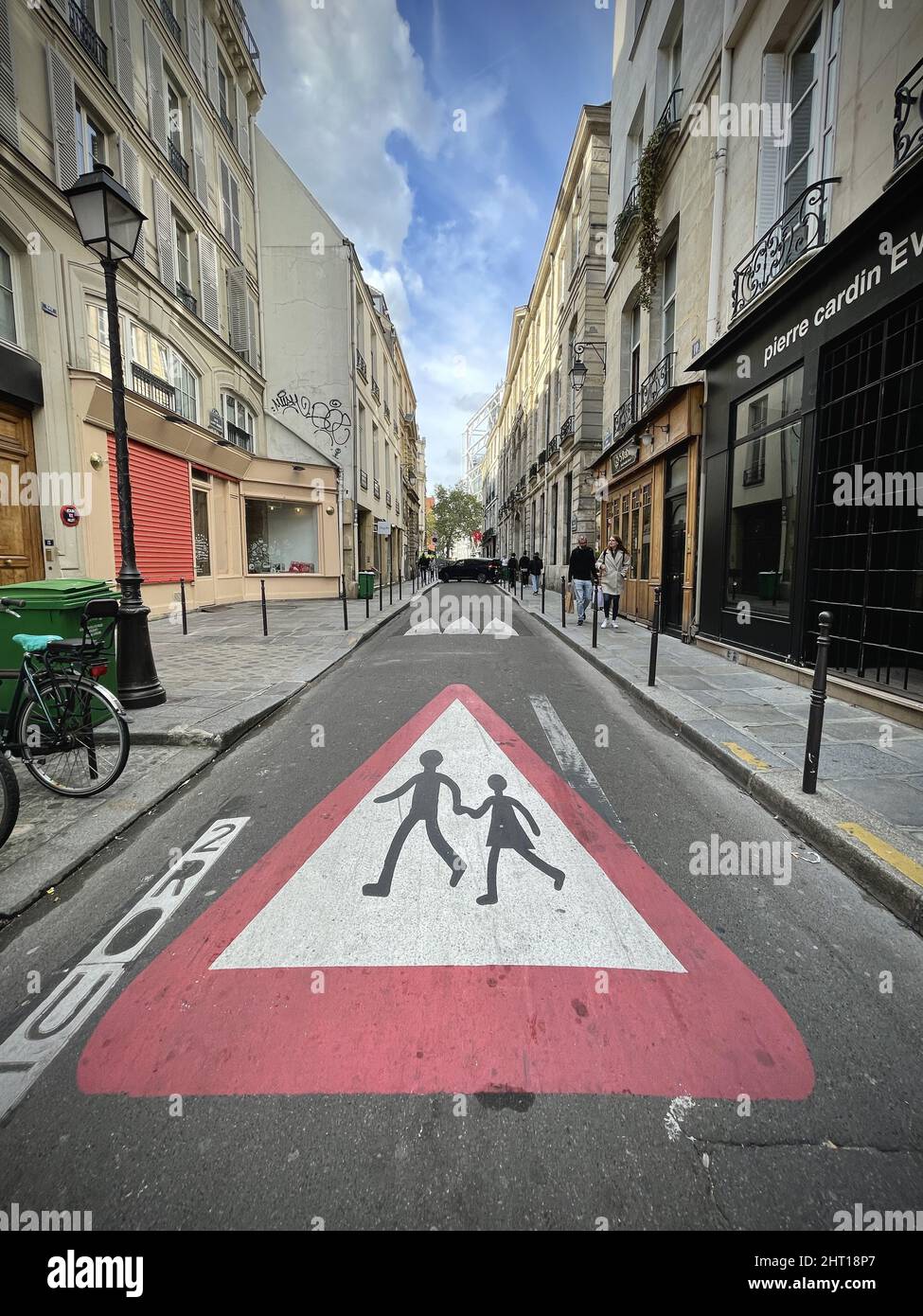 Vertical shot of a pedestrian crossing sign painted on a road in Paris ...