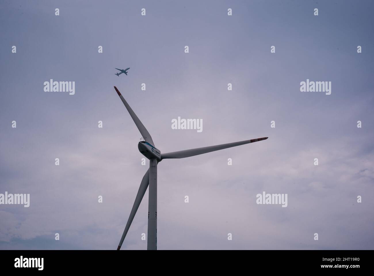 Wind turbine and a plane on a purple background Stock Photo - Alamy