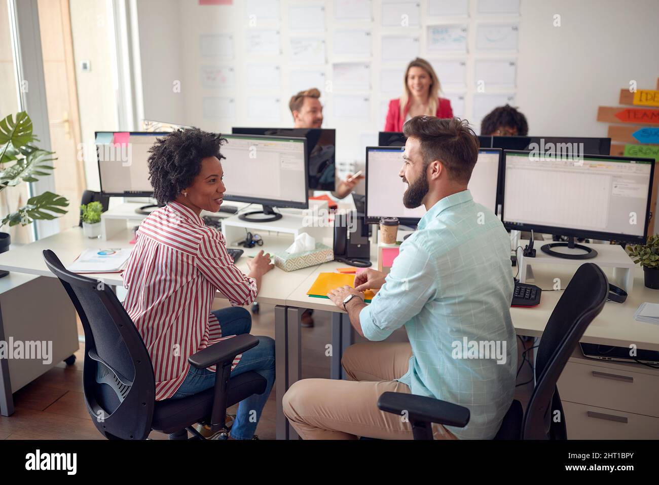 Team of coworkers consulting together in the office working on the ...