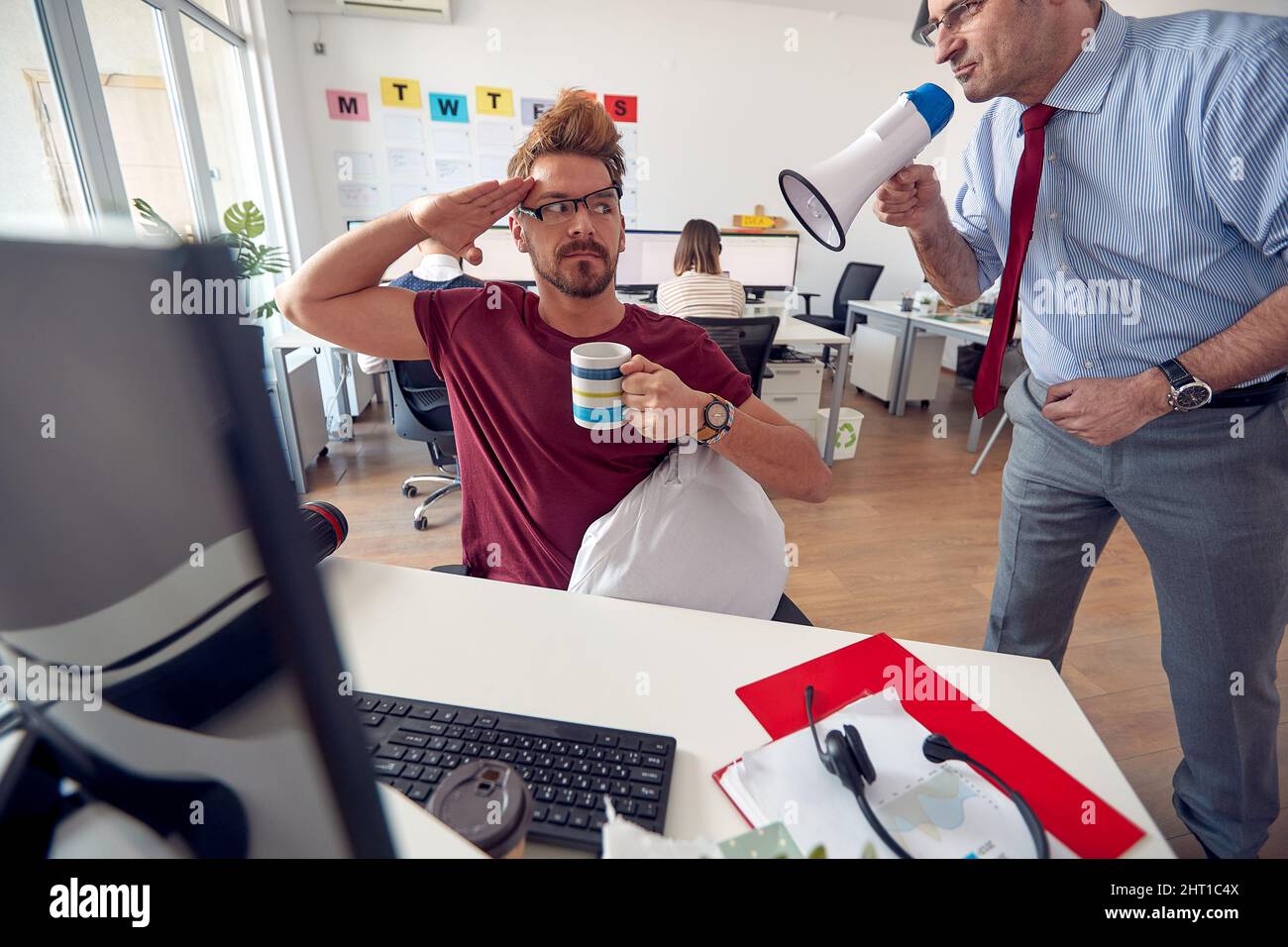 A young male employee in a uniform atmosphere in the office is ready to ...