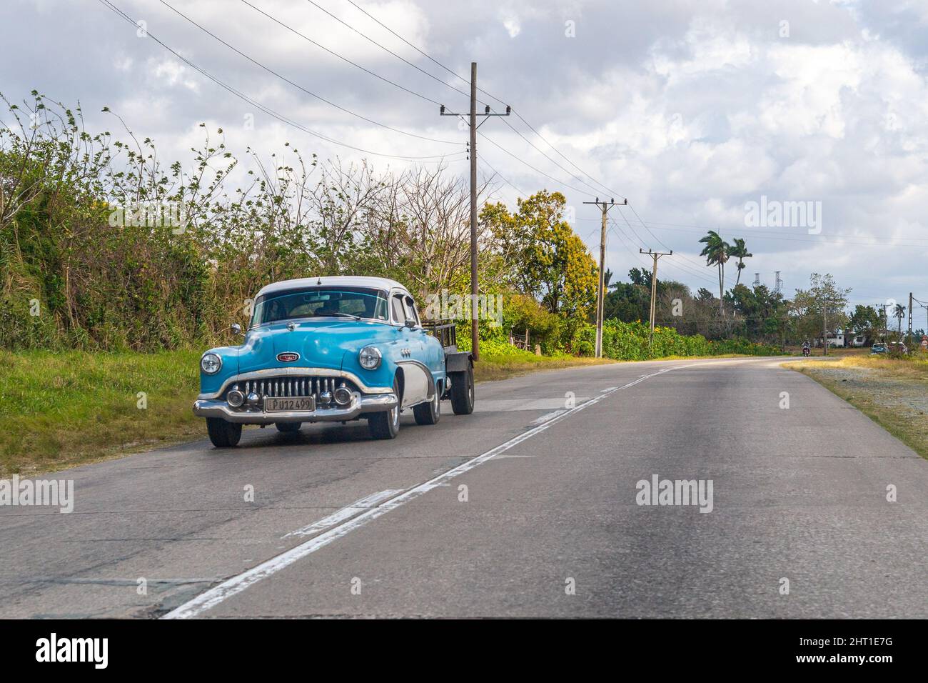 An old vintage American car driving on a rural road in Cuba Stock Photo ...