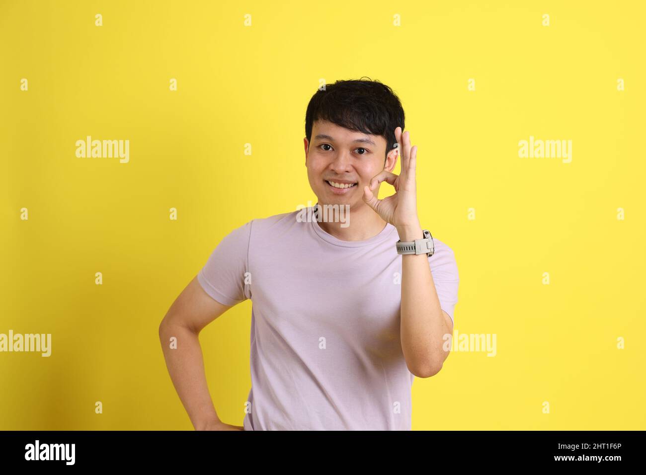 The young adult Asian man standing on the yellow background Stock Photo ...