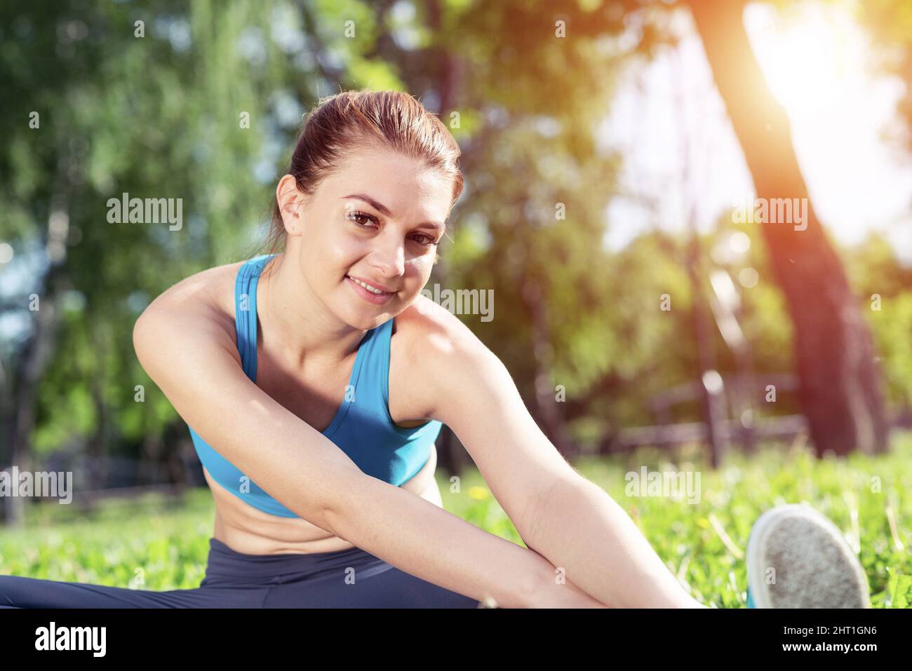 Beautiful smiling girl stretching before fitness Stock Photo - Alamy