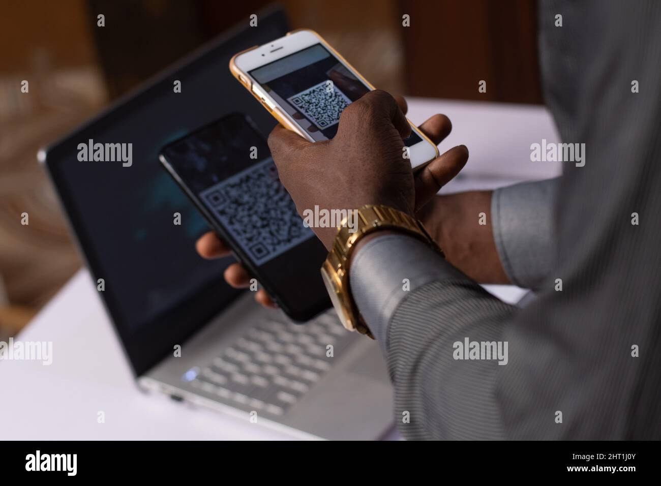 Nigerian man scanning a QR code with his smartphone from another ...