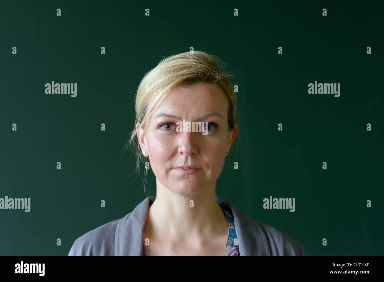 Close up of a aAttractive blond teacher staring at the camera as though ...