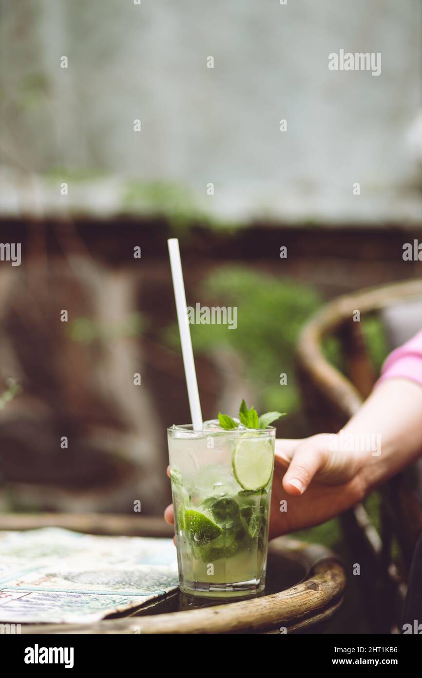 Vertical closeup of the hand taking a glass of mojito drink Stock Photo ...