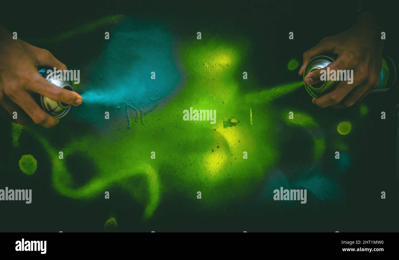 Closeup of the man's hands holding two bottles of spray paints for ...