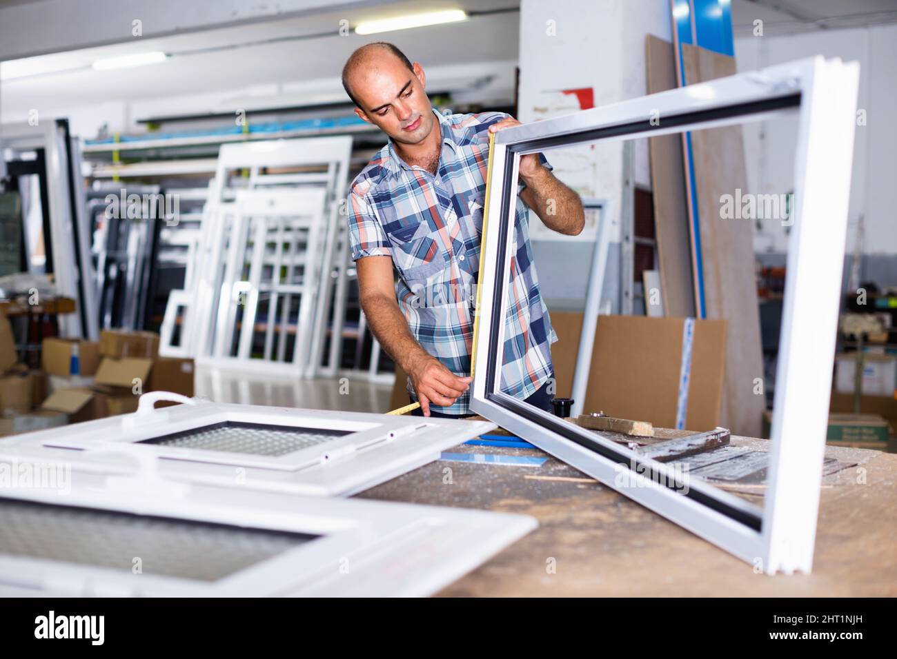 Male supervisor controlling quality of finished PVC window frame Stock ...