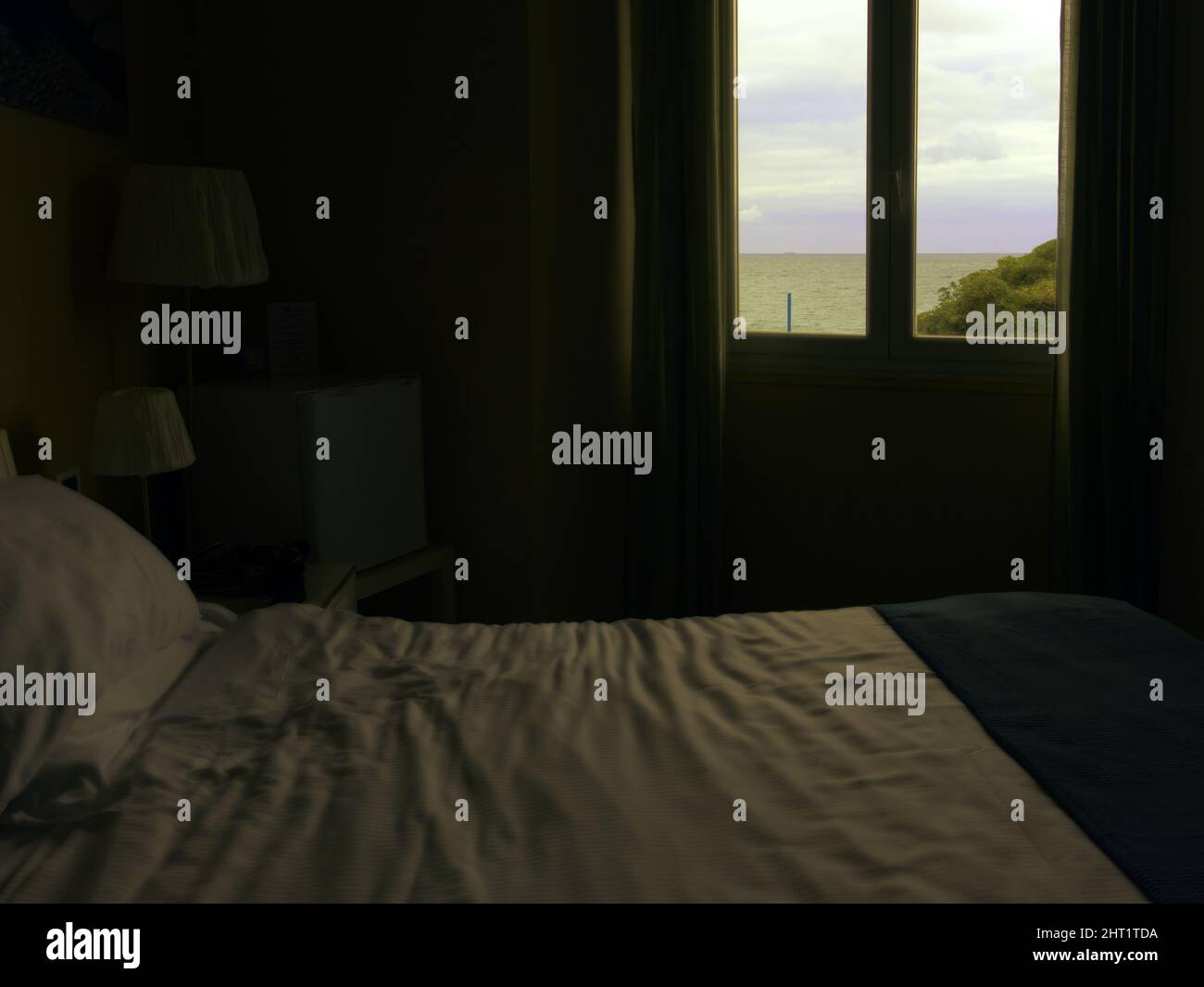 the light of dawn enters the window and lights up the bed in an empty ...