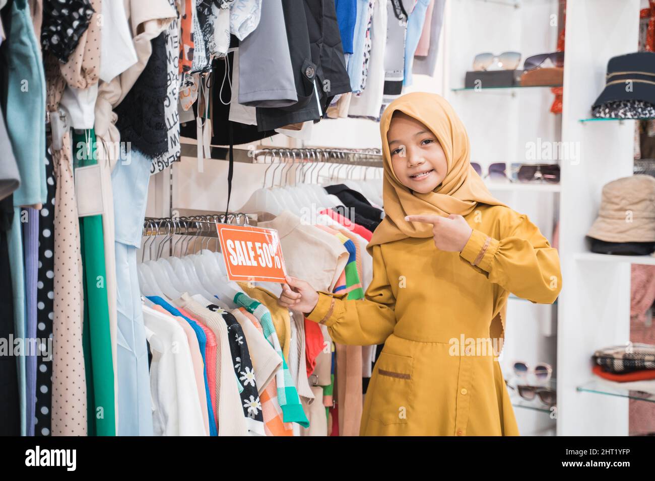 Little girl shopping new clothes in a shop at the mall Stock Photo - Alamy