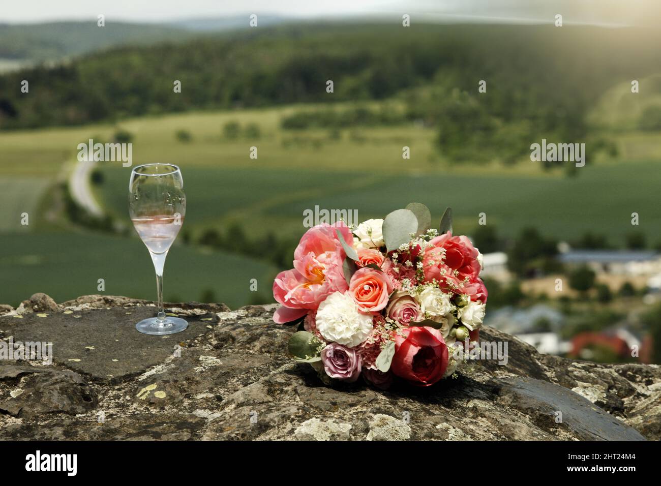 Glass of champagne with a beautiful bouquet of flowers on the rock ...