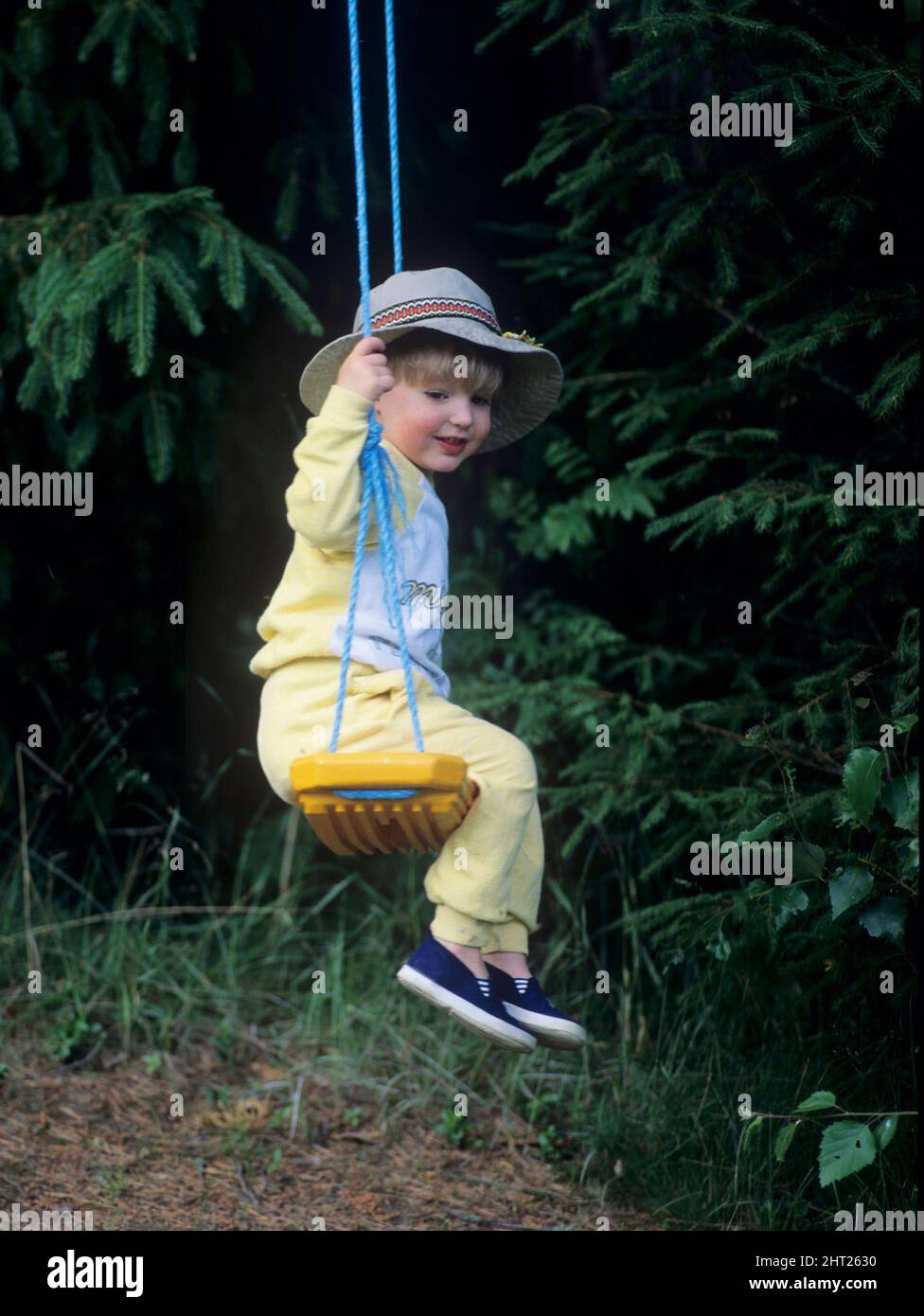 Boy on swing Stock Photo - Alamy