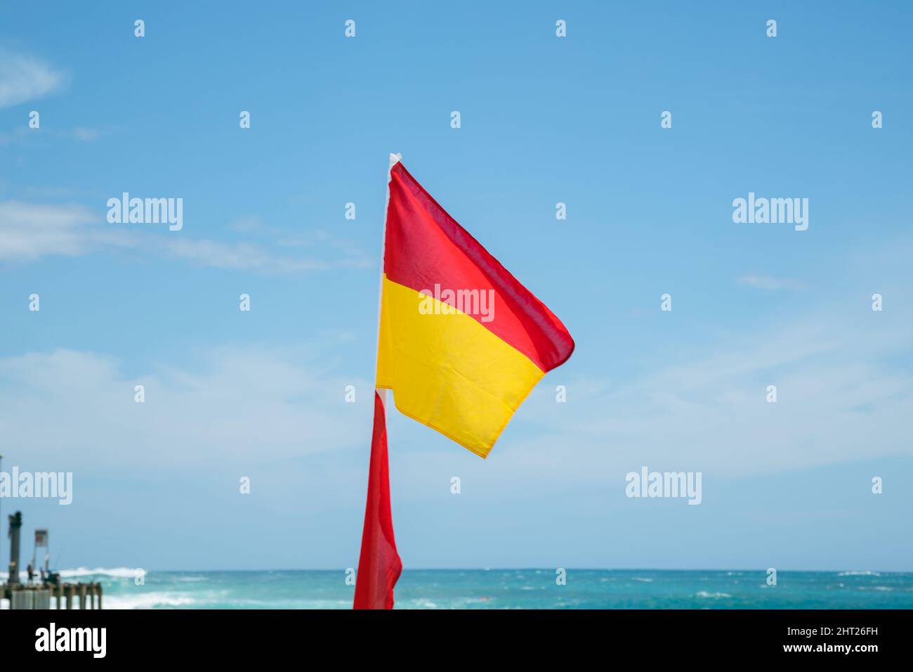Red yellow lifeguard flag flying on a beach at Port Campbell in ...