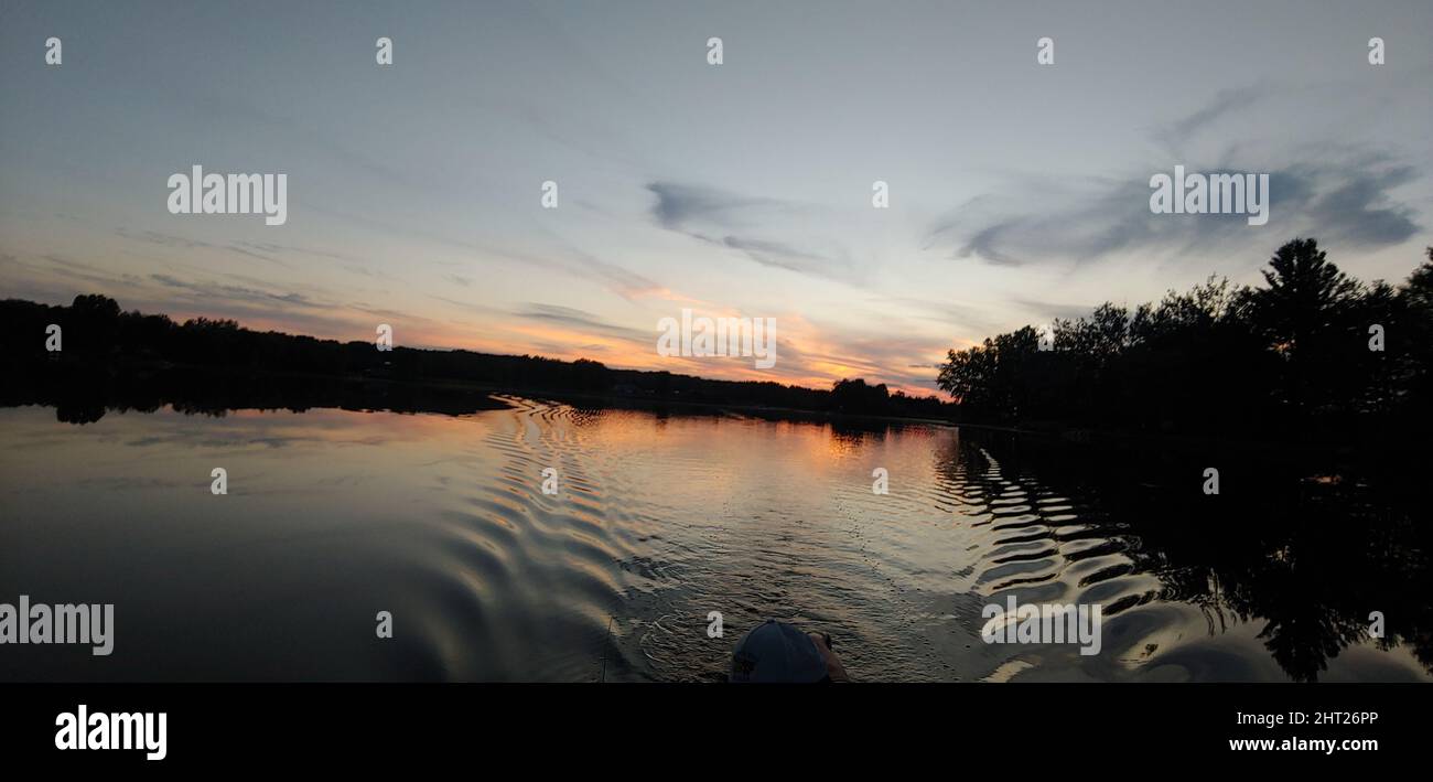 Panoramic view of a wavy lake with tree silhouettes in the sunset Stock ...