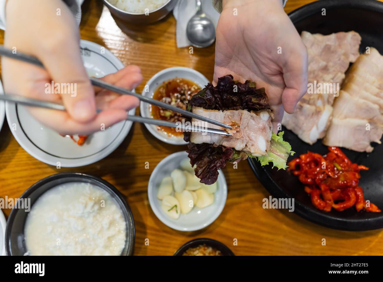 Put meat and salted shrimp on lettuce with chopsticks to make bossam ...