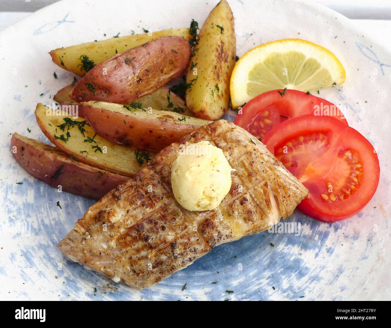 Fish fillet with wedged potatoes Stock Photo - Alamy