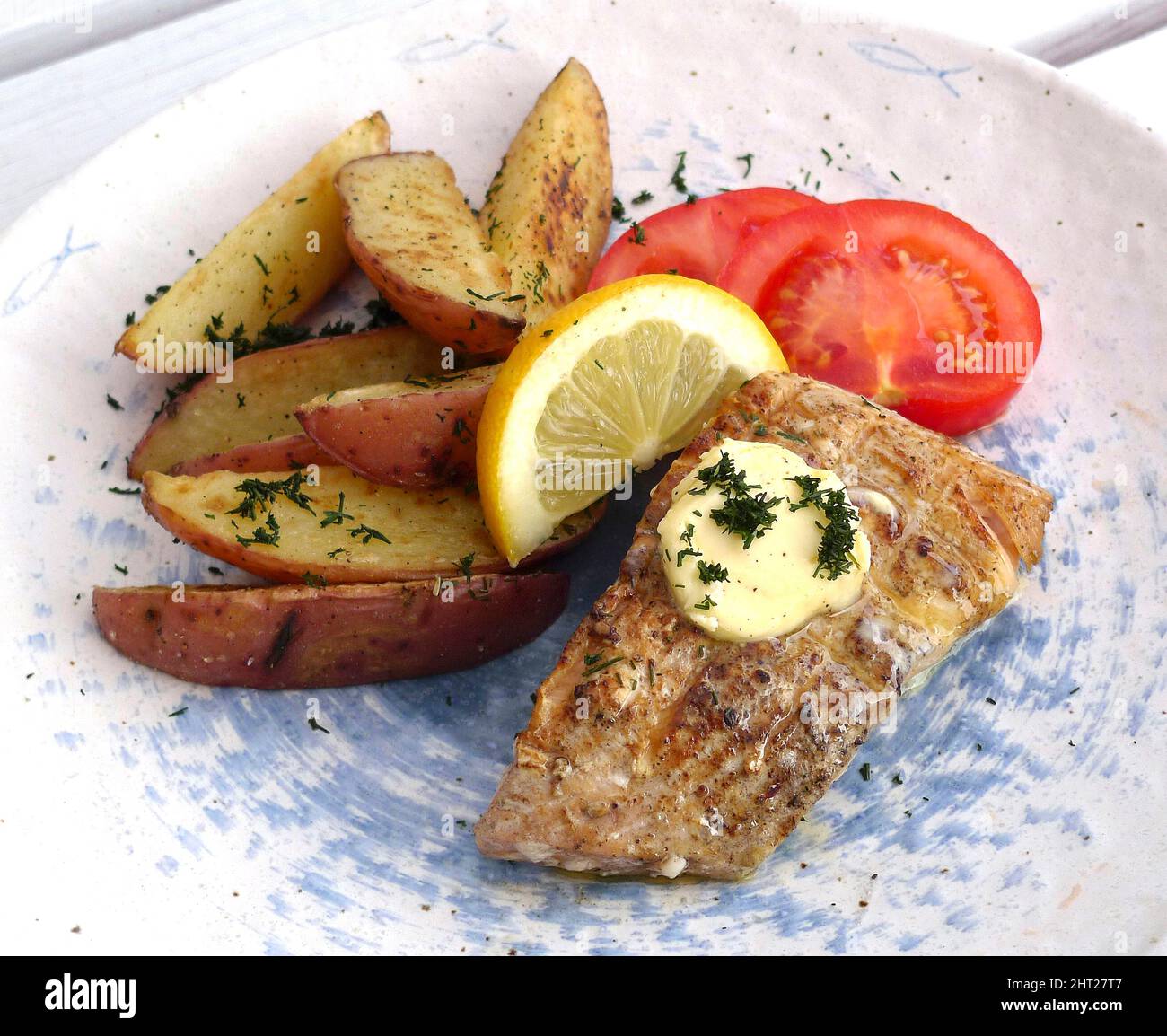 Fish fillet with wedged potatoes Stock Photo - Alamy