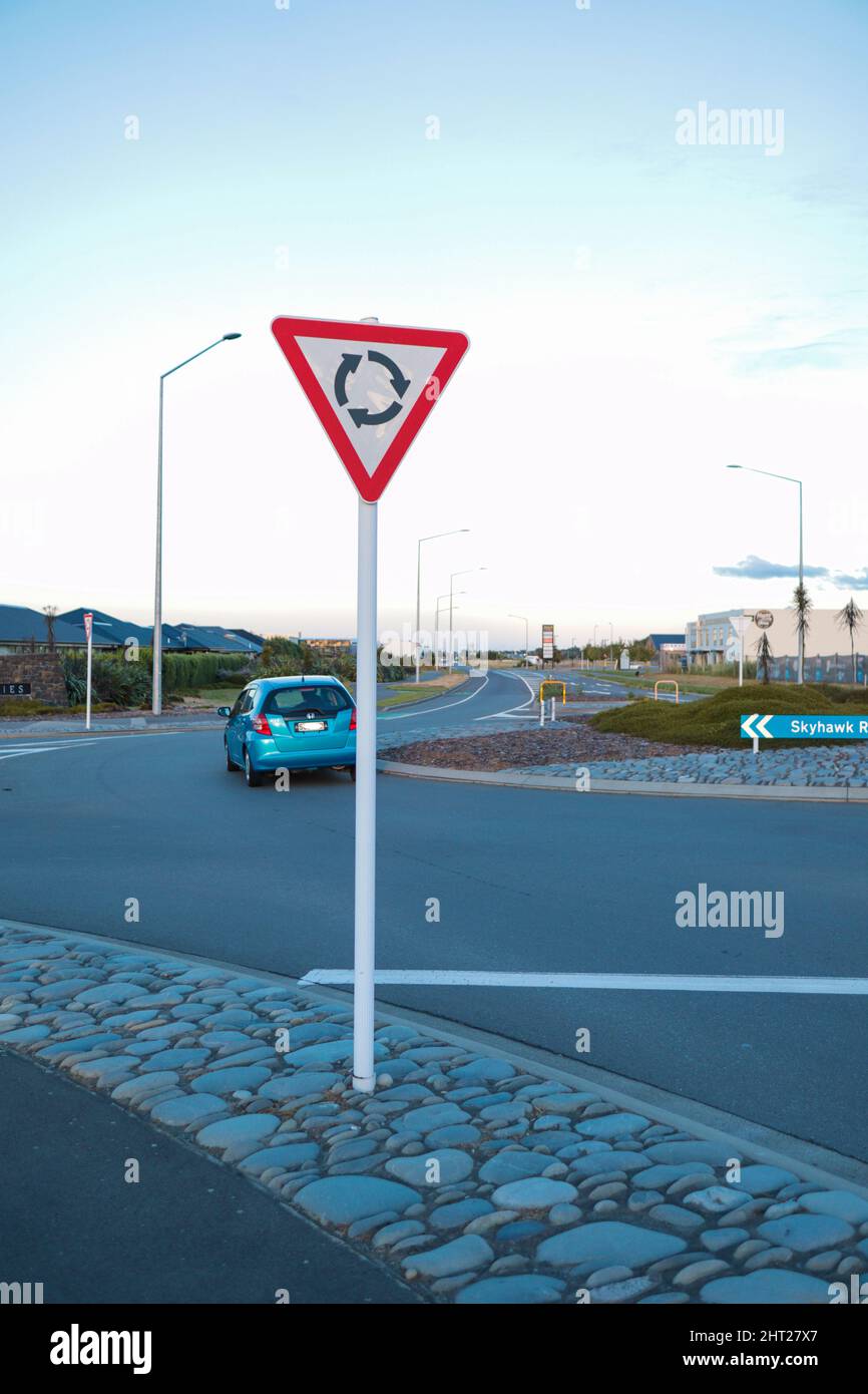 Vertical shot of traffic signs around New Zealand with car on the road ...
