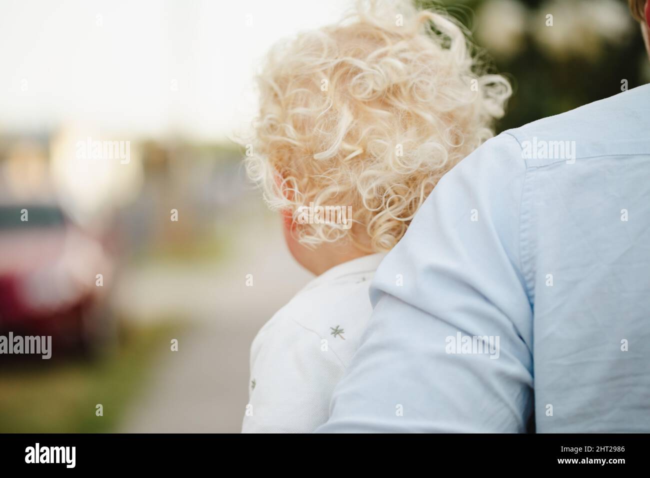 Closeup shot of a man hugging a young boy on the blurry background ...