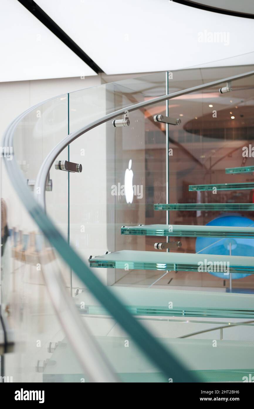 Vertical of glass spiral staircase with a background of the Apple store ...