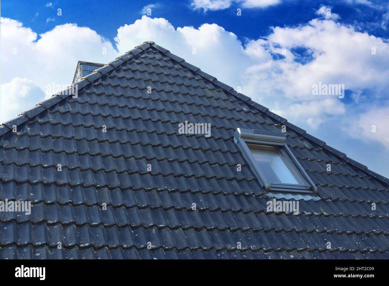 Open roof window in velux style with black roof tiles Stock Photo - Alamy