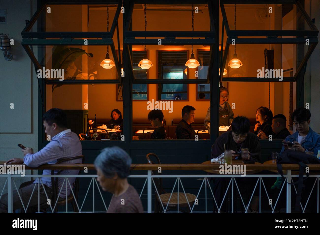 View of people sitting in a cafe in the evening in Shenzhen's urban ...