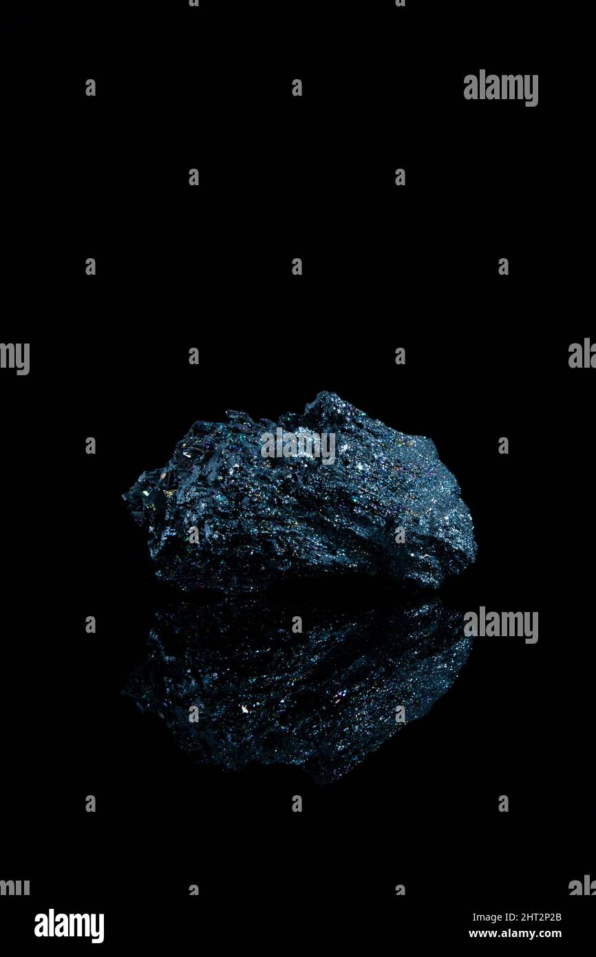 Vertical shot of a bornite mineral isolated on black background Stock ...