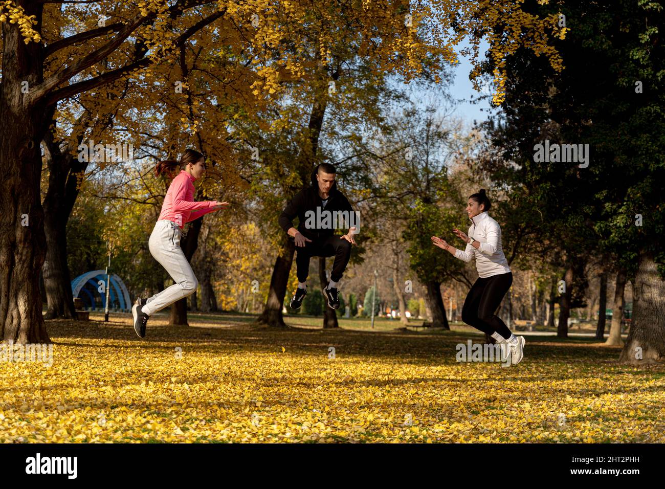 Three attractive and amazing friends are jumping to warm up before ...