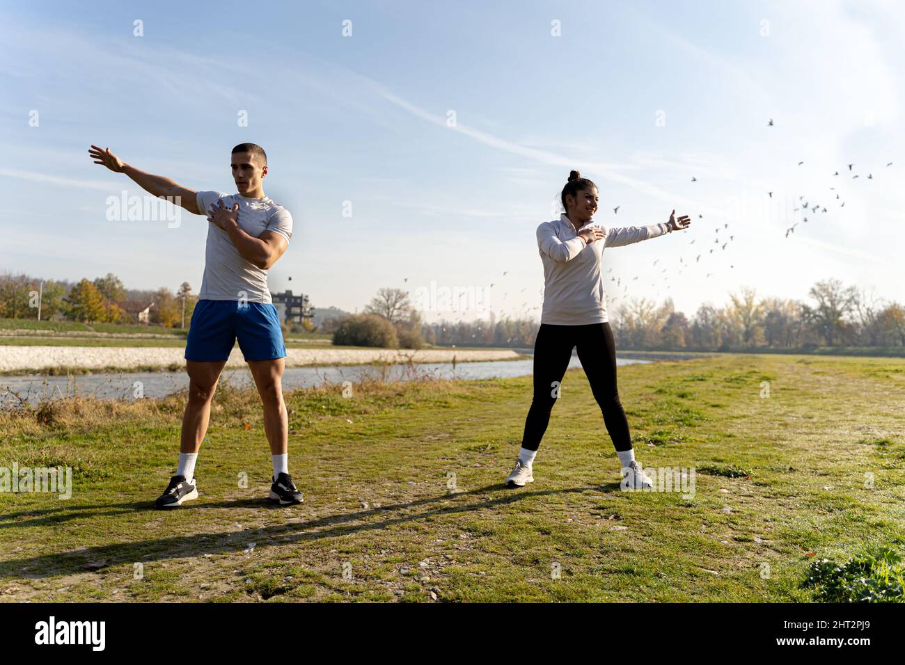 Two amazing and attractive fit friends are warming up together and ...