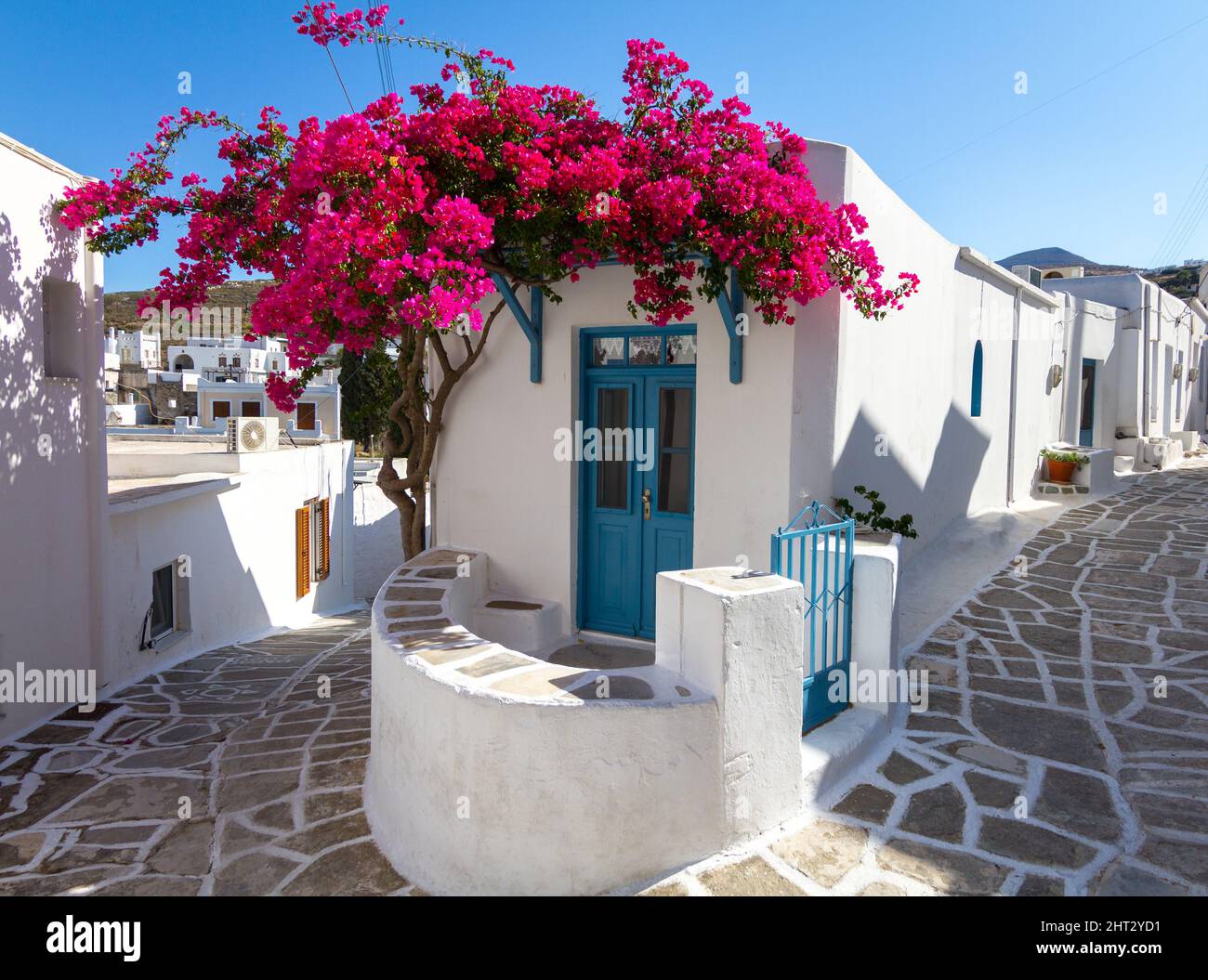 Beautiful sunny view of a traditional house with a blue door and ...