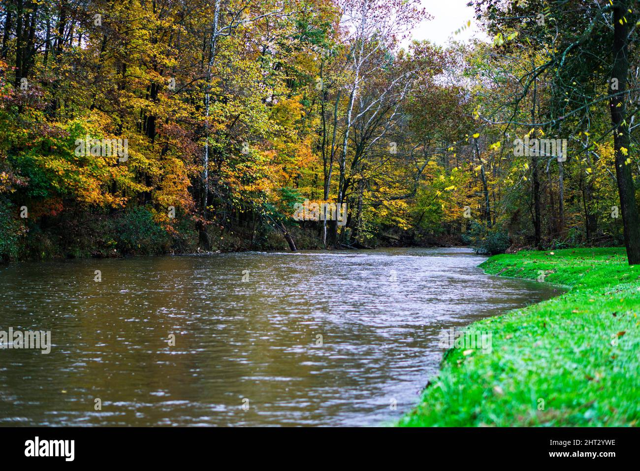 River flowing through green lawns and colorful trees in autumn Stock ...