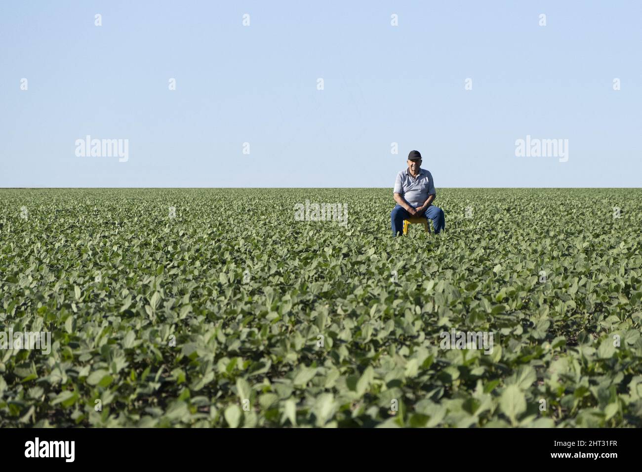 Tranquil scenery of farmer sitting in the field Stock Photo - Alamy