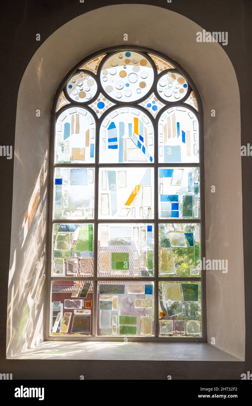 Vertical of a beautiful multicolored mosaic arched window with a ...