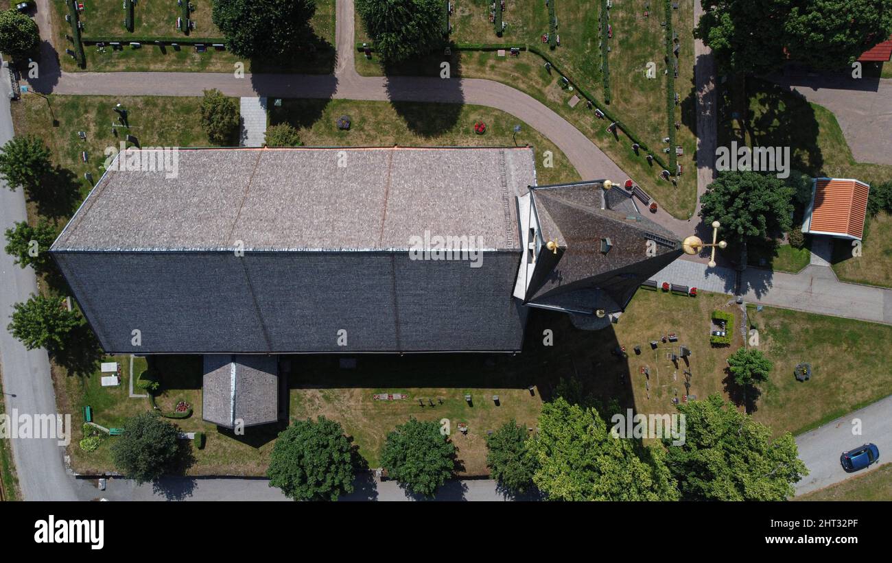 Aerial view of a church rooftop surrounded by trees and a graveyard ...