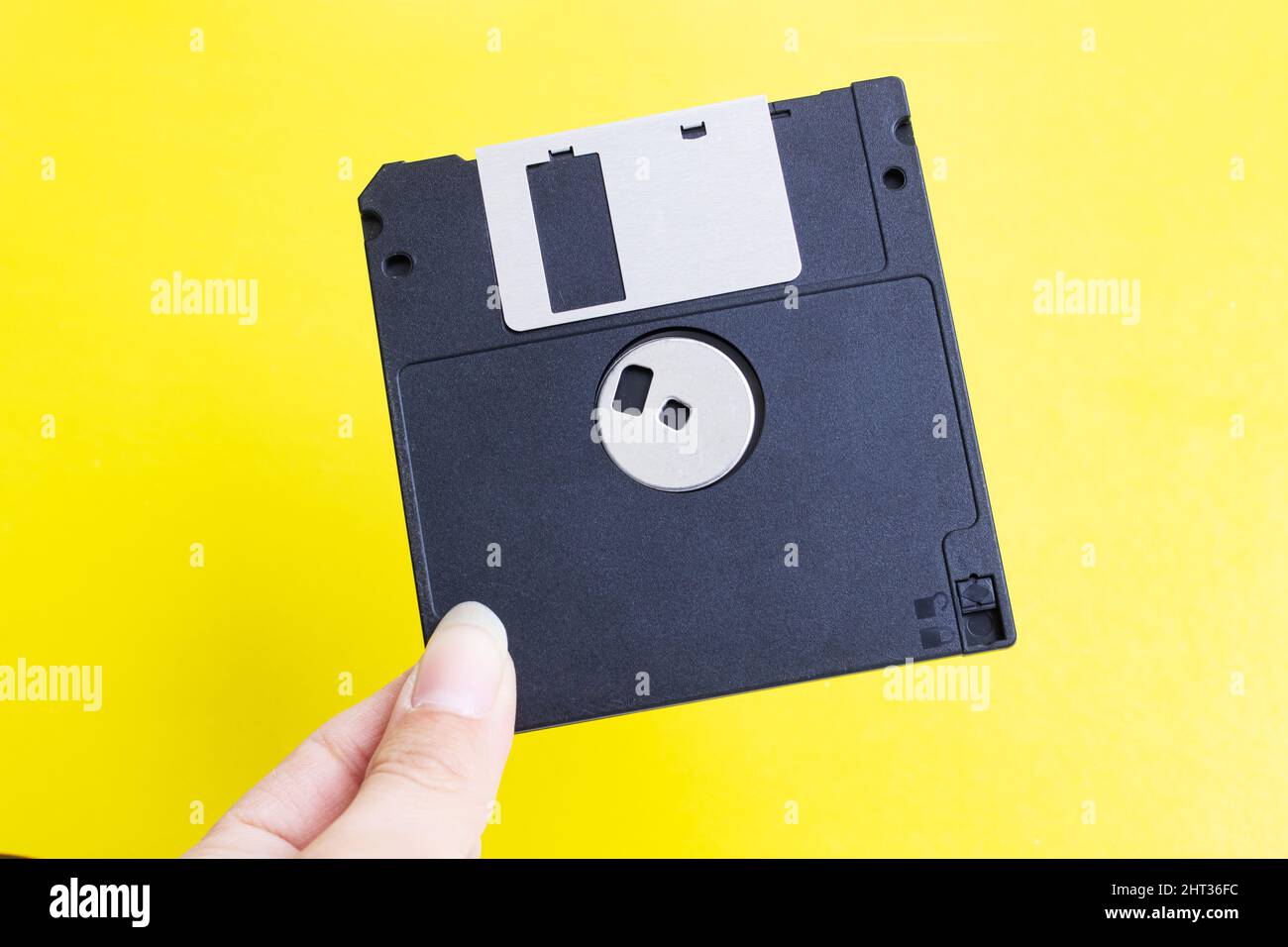 Floppy disk in hand on yellow background Stock Photo - Alamy