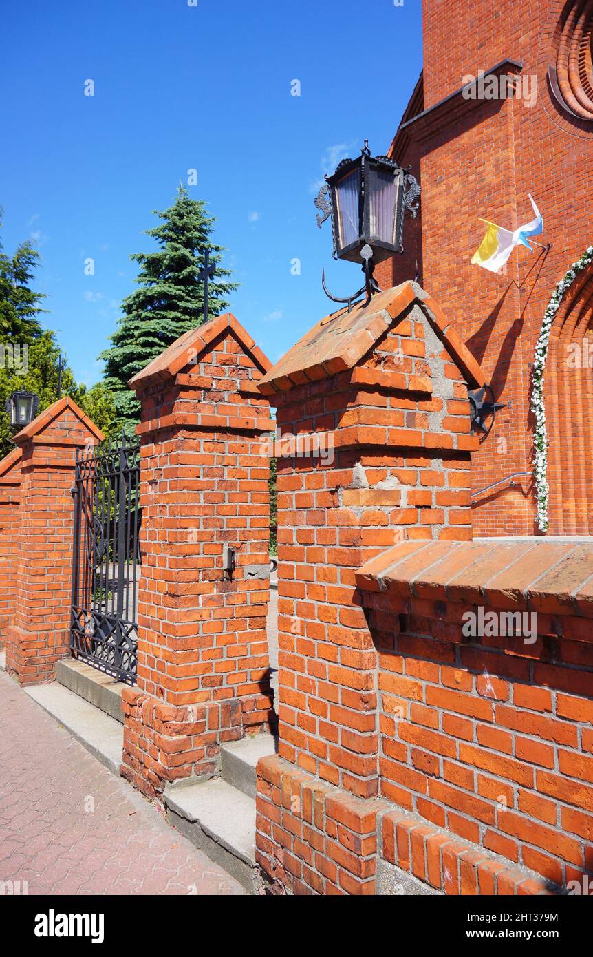 Vertical shot of a Catholic church wall made of bricks by the entrance ...