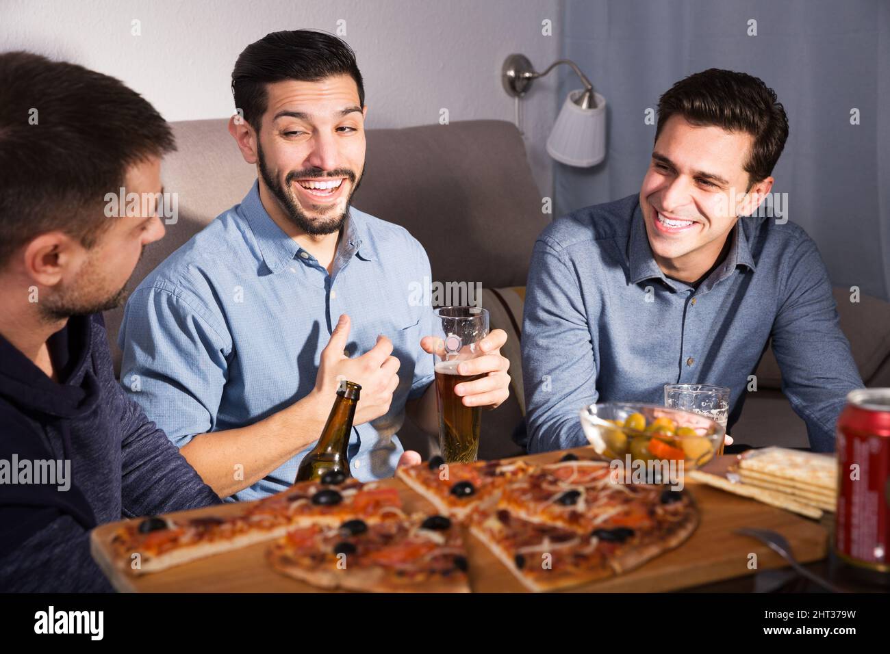 Three men talking and laughing at home Stock Photo - Alamy