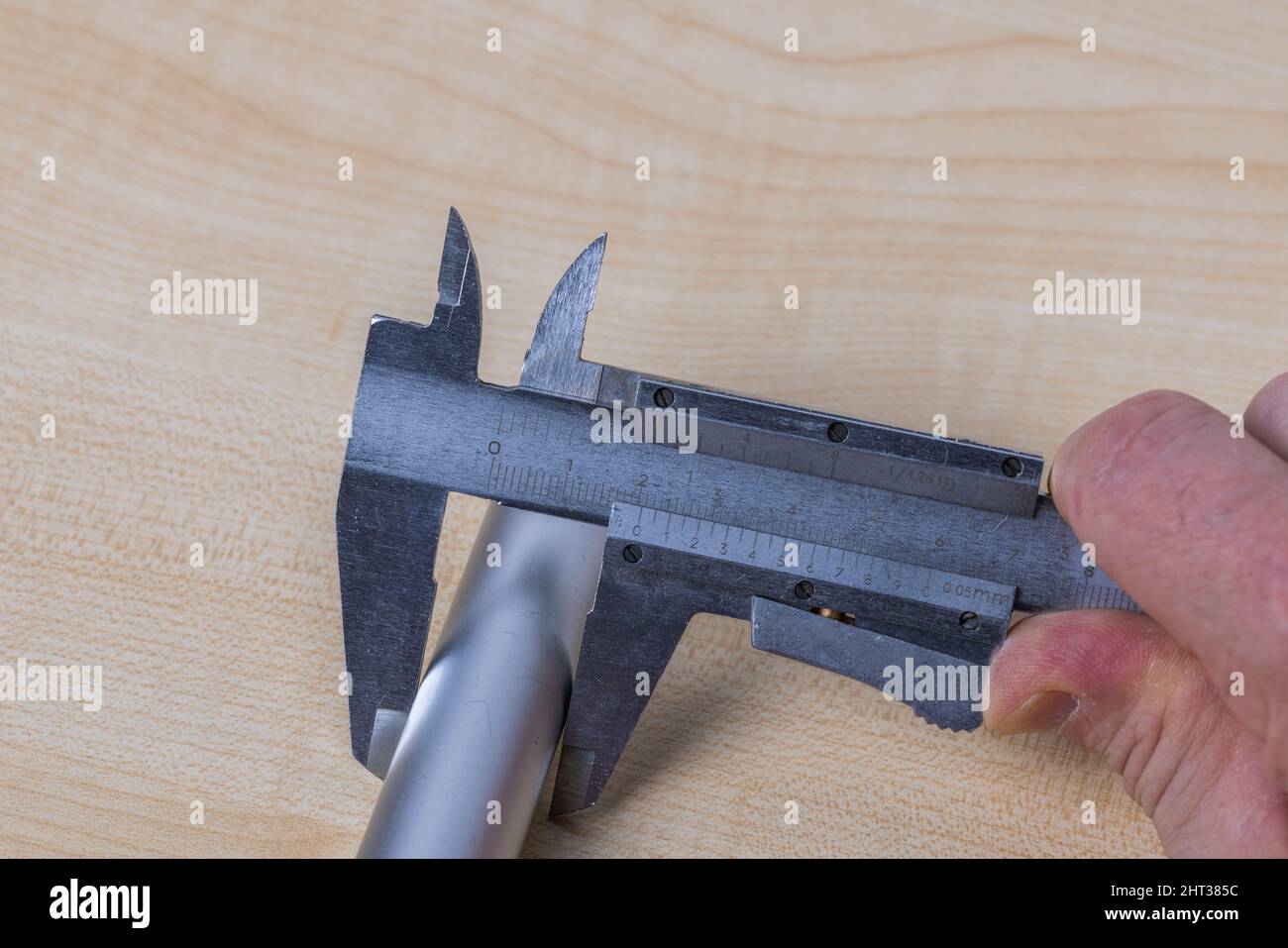 Close up view of hands man measuring an aluminum pipe with an calipers ...