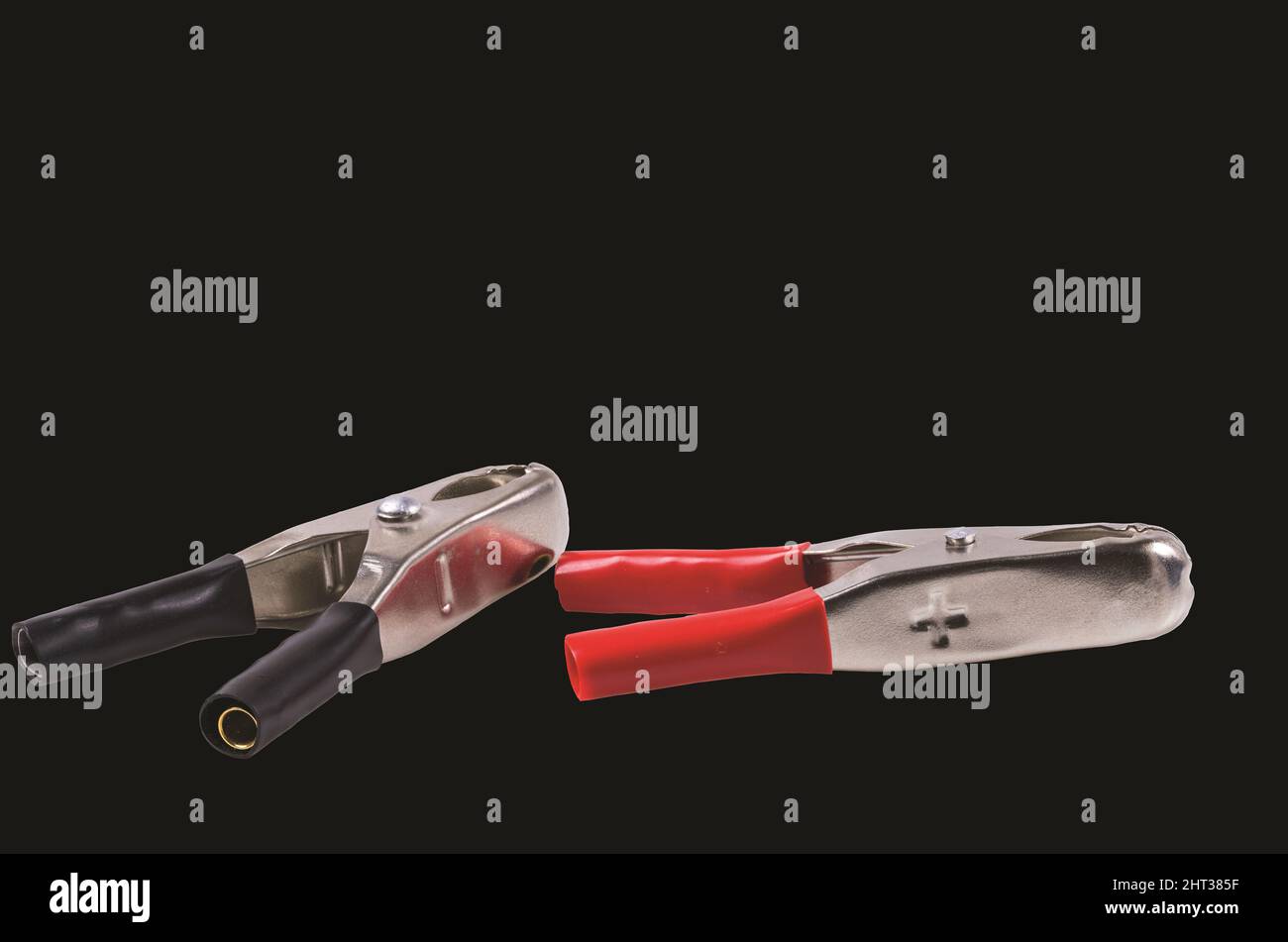 Close up view of two clips for charging battery isolated on black ...