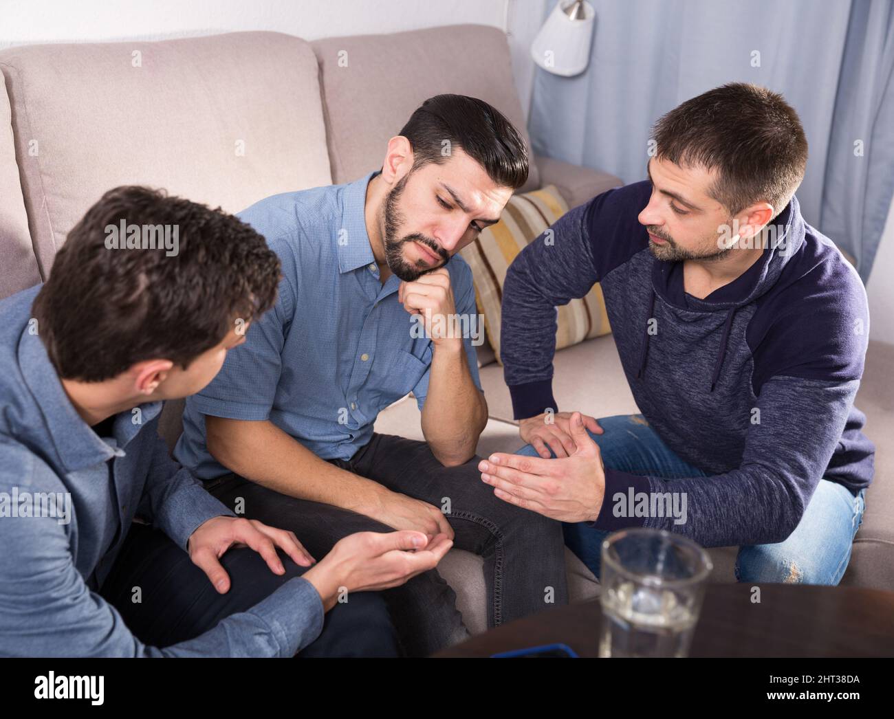 Upset friends talking on couch Stock Photo - Alamy