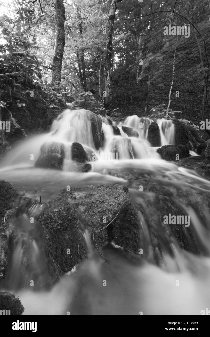 A grayscale, vertical shot of a waterfall cascade Stock Photo - Alamy