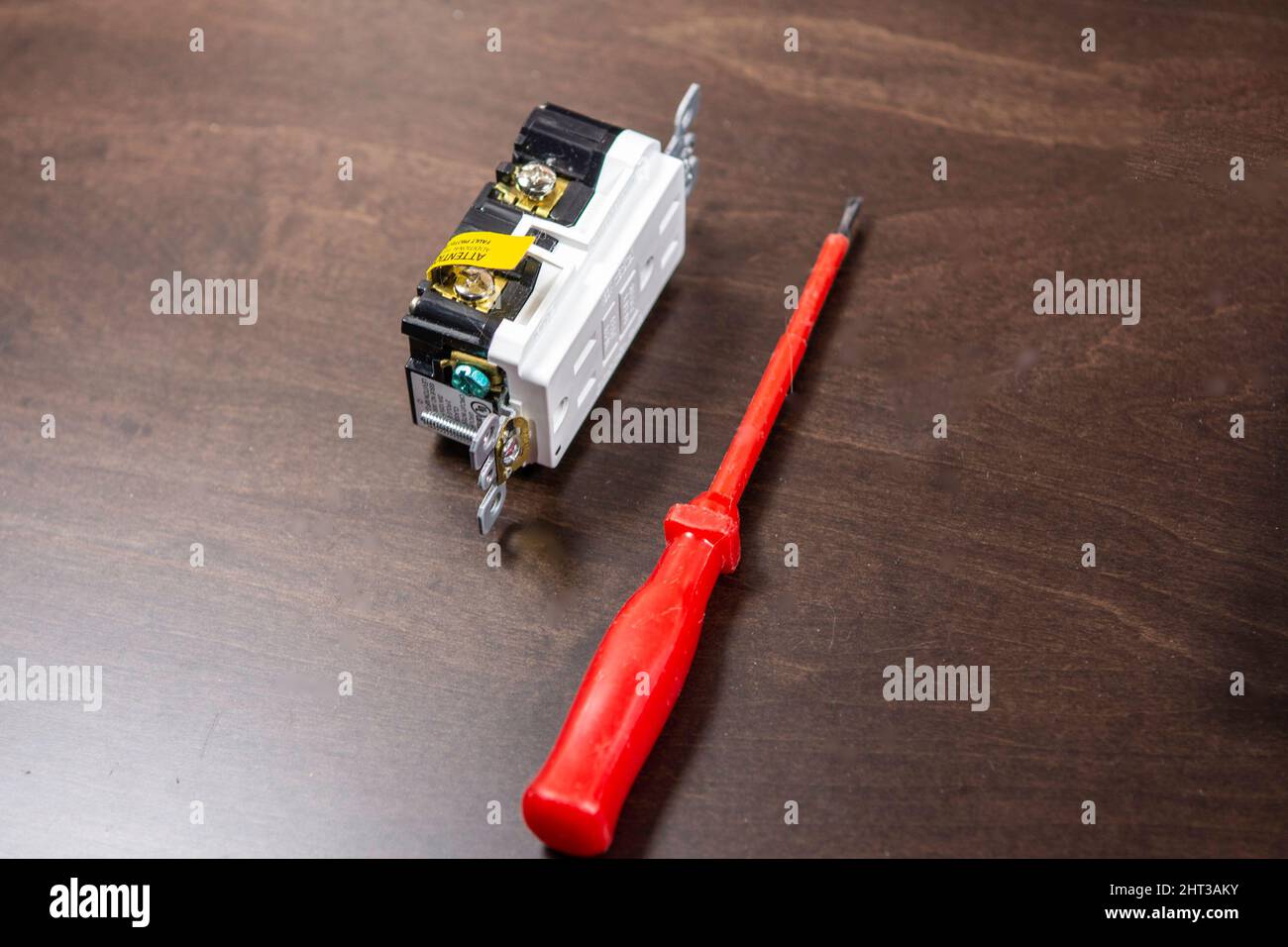 A tested electrical outlet lies on the table before being installed in ...
