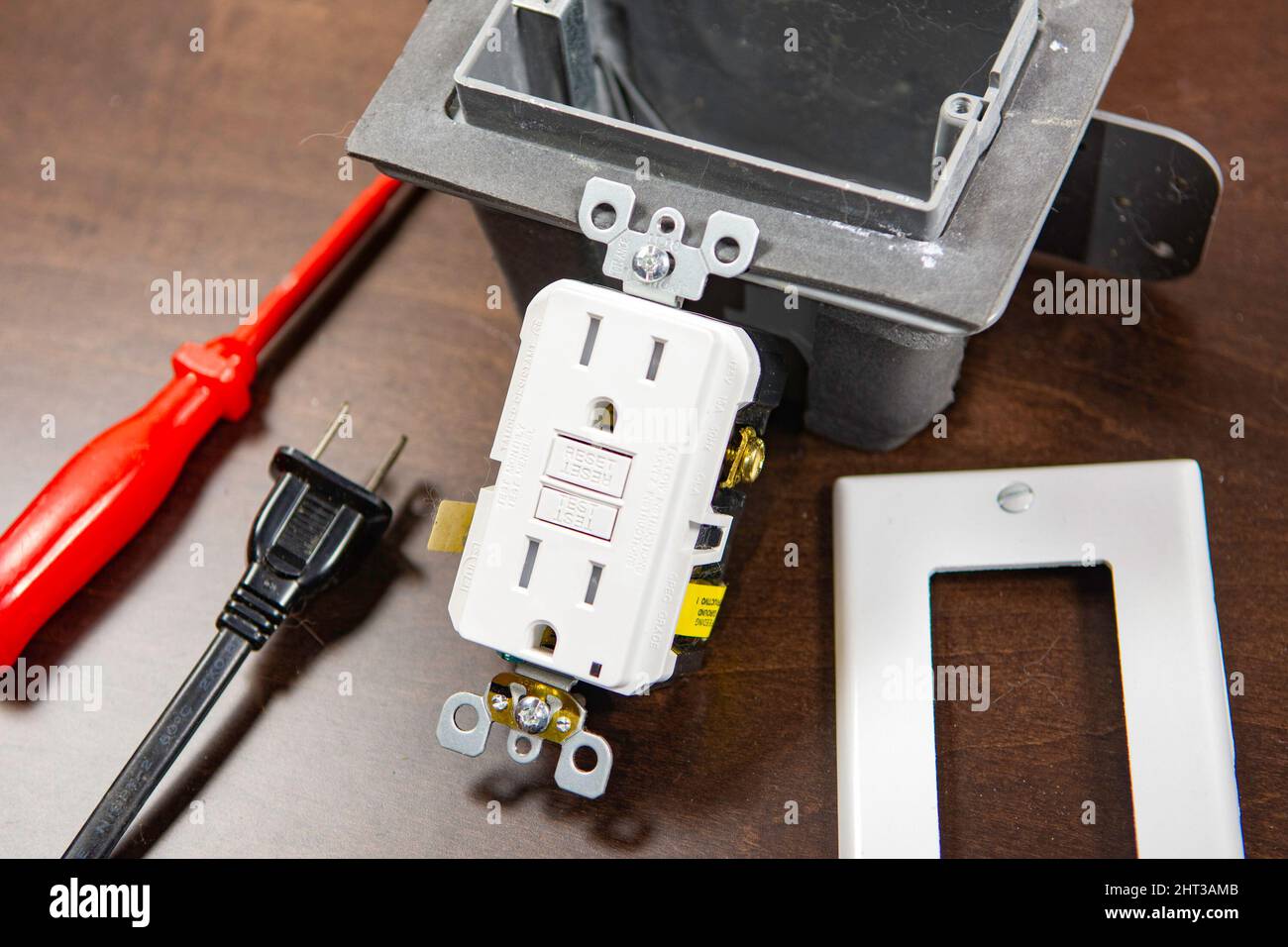 A tested electrical outlet lies on the table before being installed in ...