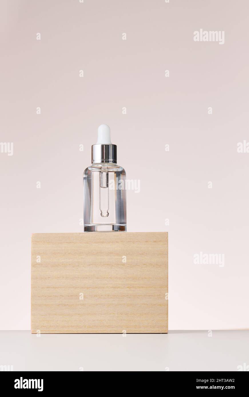 glass transparent white bottle with a pipette stands on a wooden podium ...