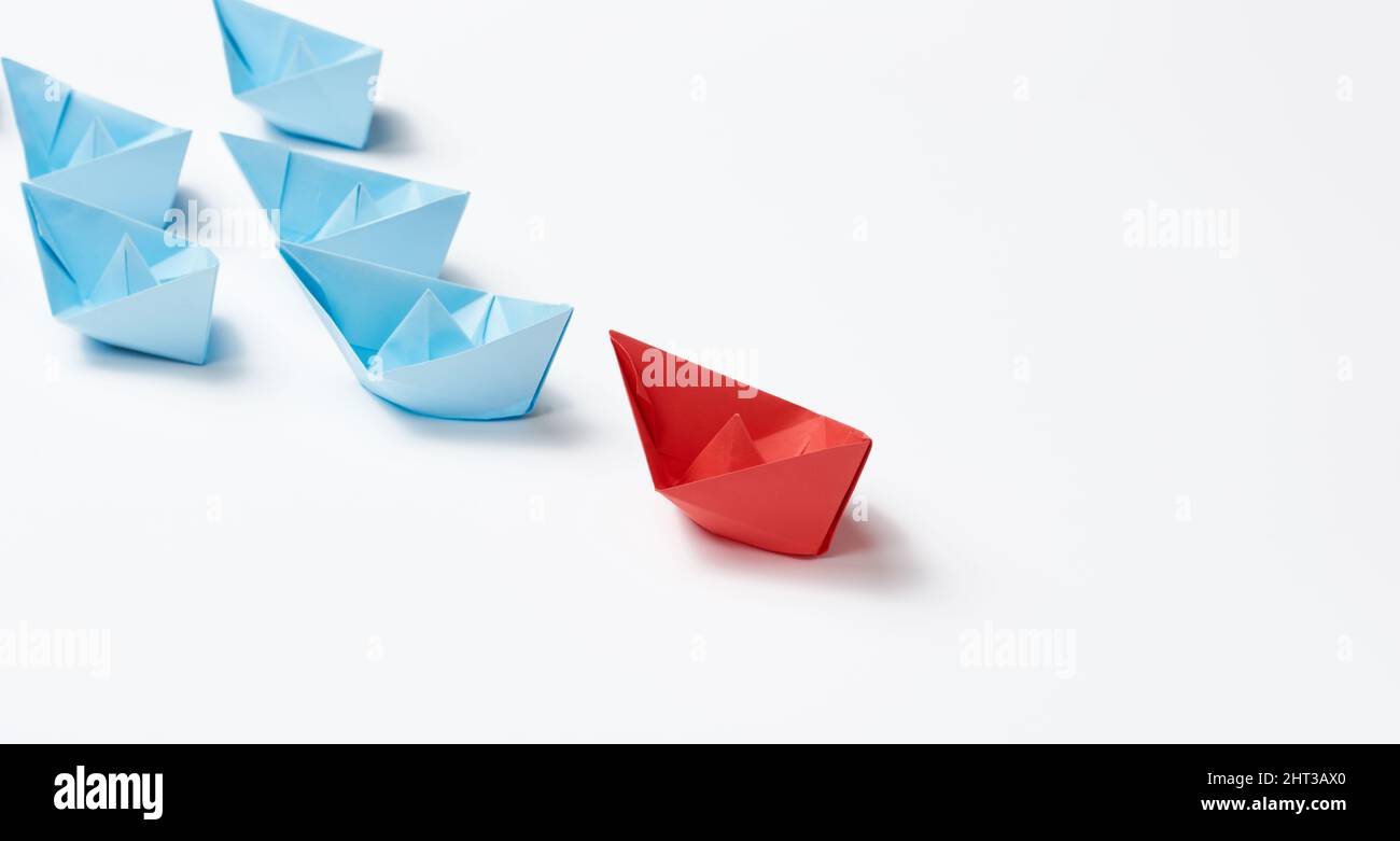 group of paper boats on a white background. concept of a strong leader ...