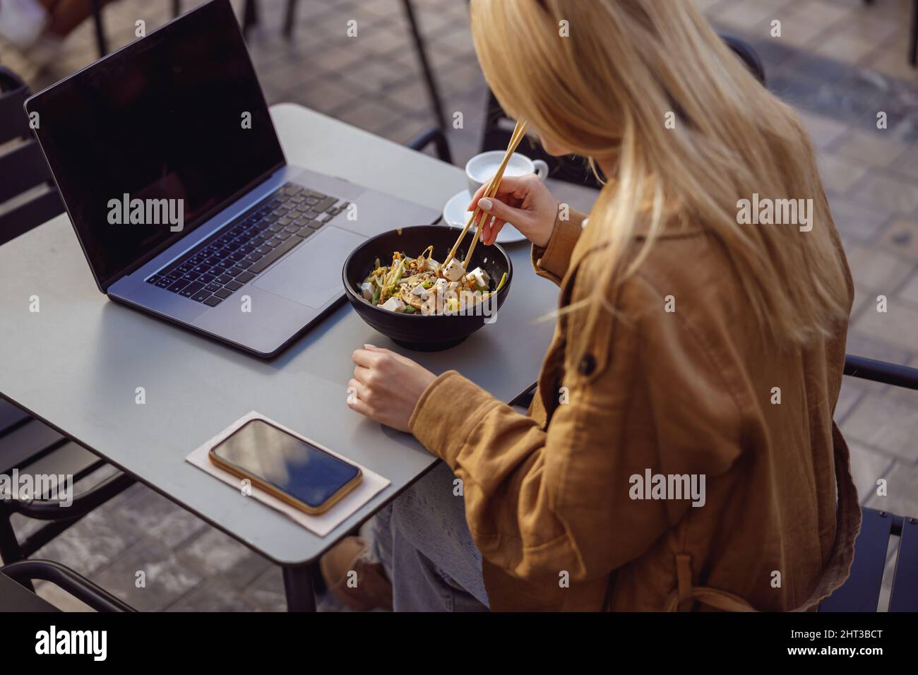 Woman on lunch break eating food outside using chopsticks Stock Photo ...