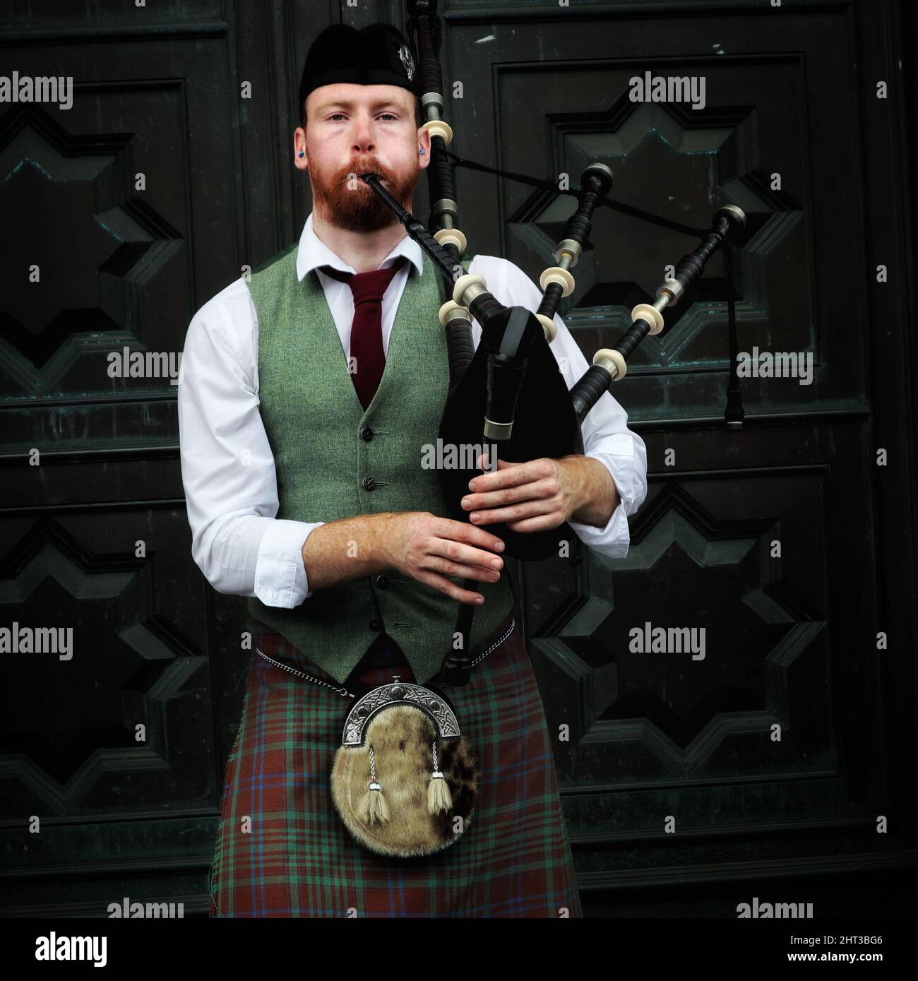 Performer playing the bagpipes in traditional Scottish clothing in ...
