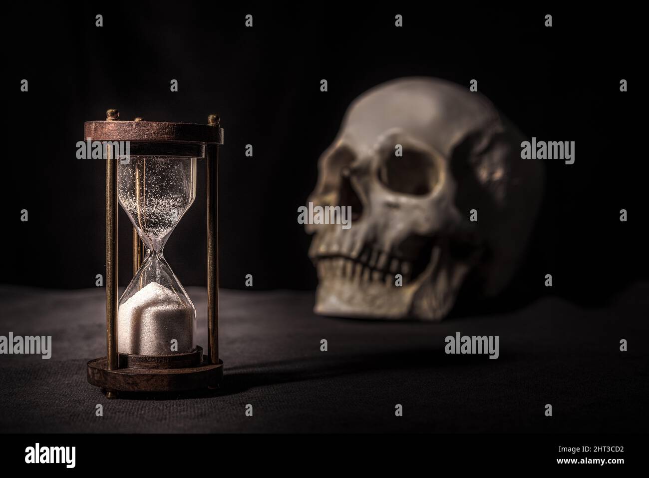 Closeup shot of a finished hourglass and a skull on a dark background ...
