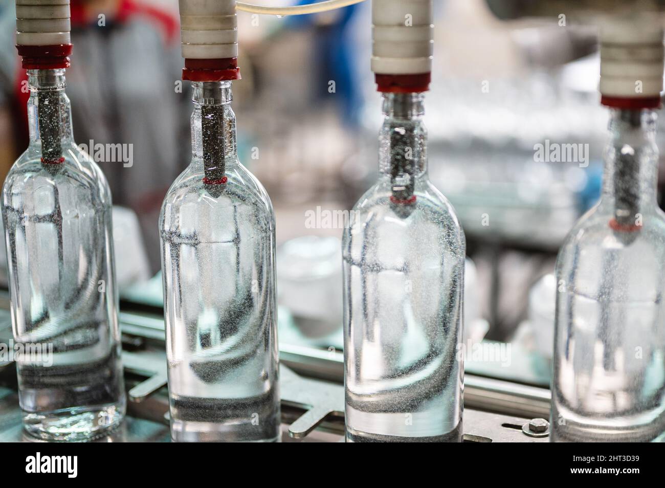 Equipment pours vodka into glass bottles on production line Stock Photo ...