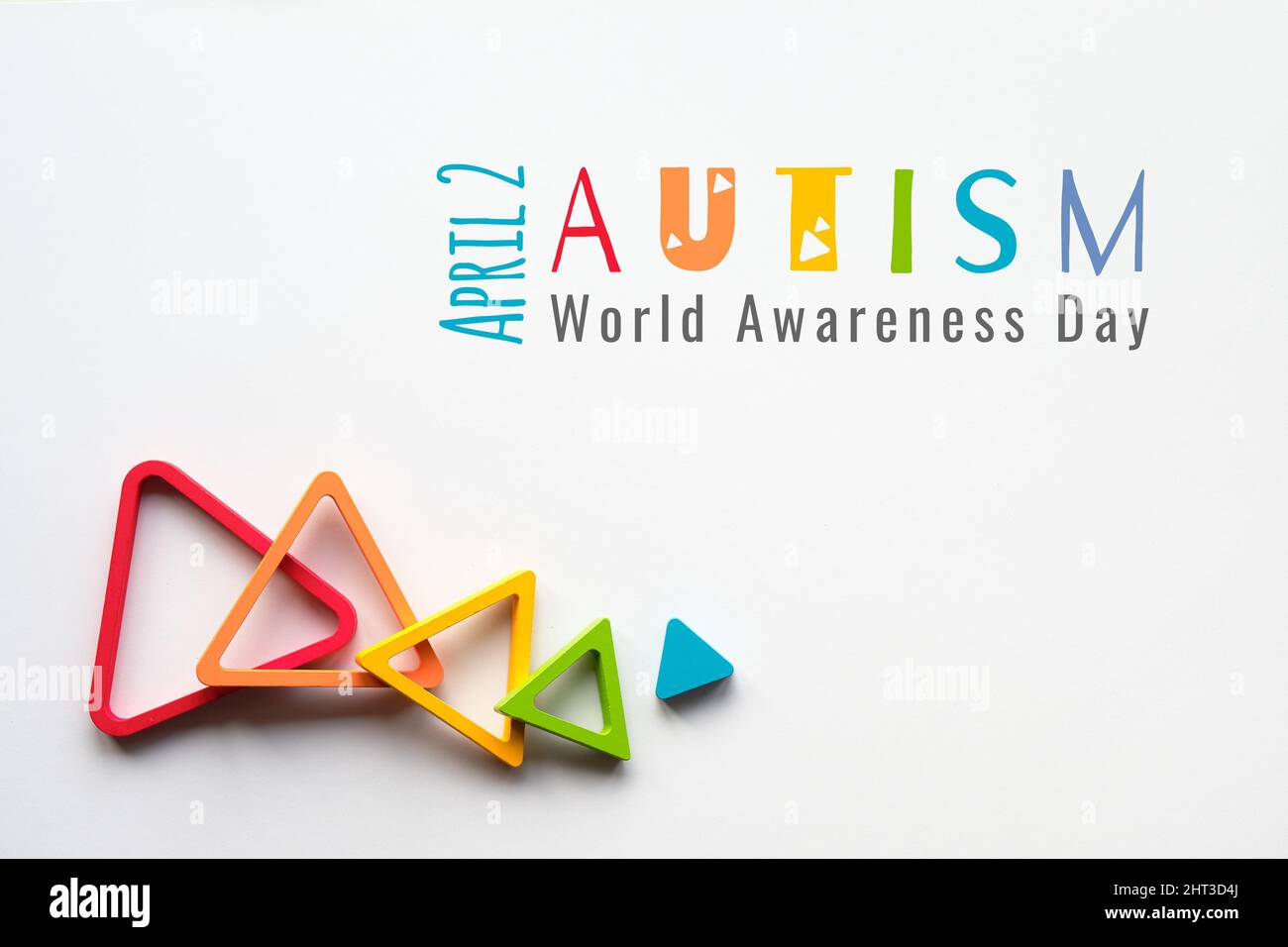 Text Autism awareness month. Nested wooden triangles painted in rainbow ...